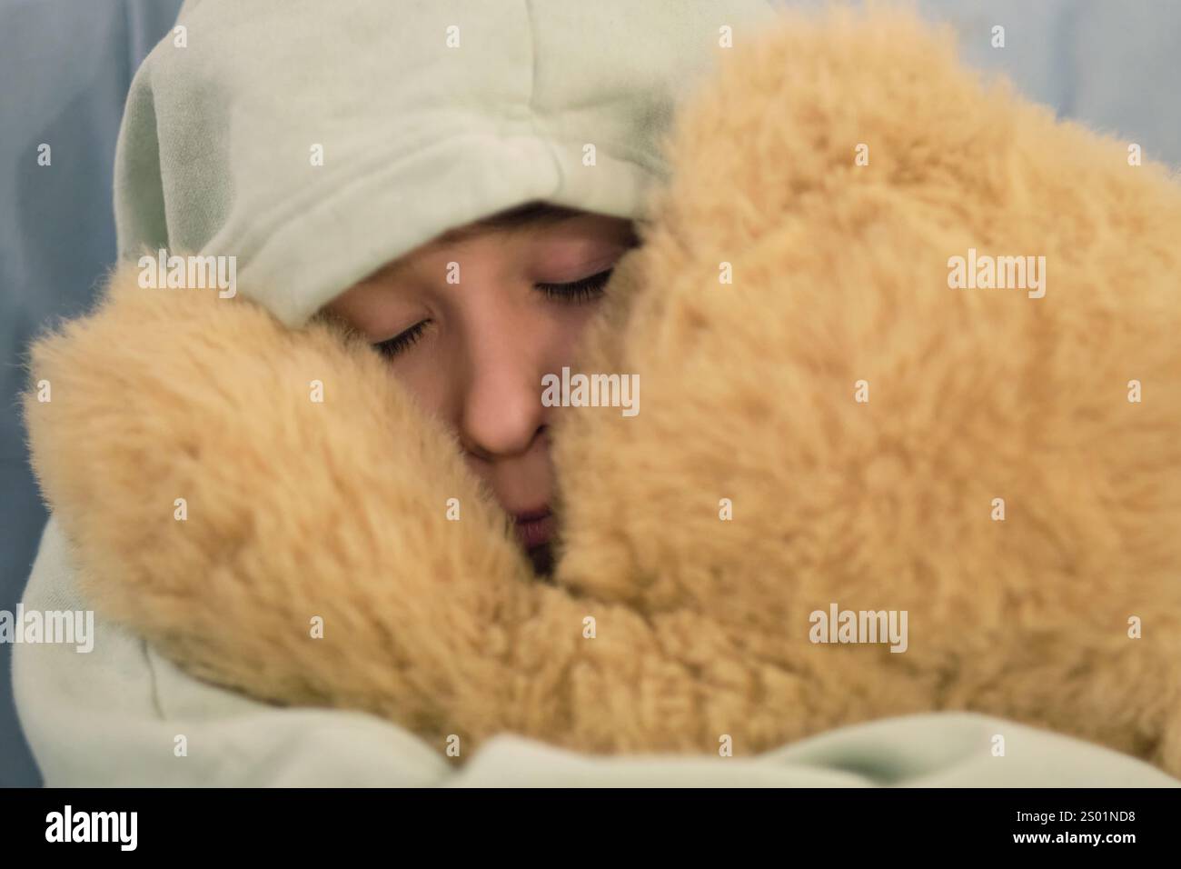 A serene child cuddling a fluffy teddy bear, eyes closed in comfort and ...