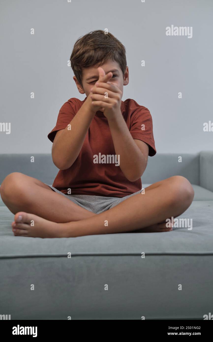 A young boy enjoying a moment of creativity, using his hands to mimic ...