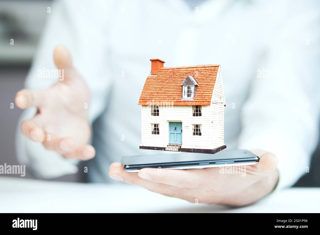 Man hand phone with house model on white background Stock Photo - Alamy