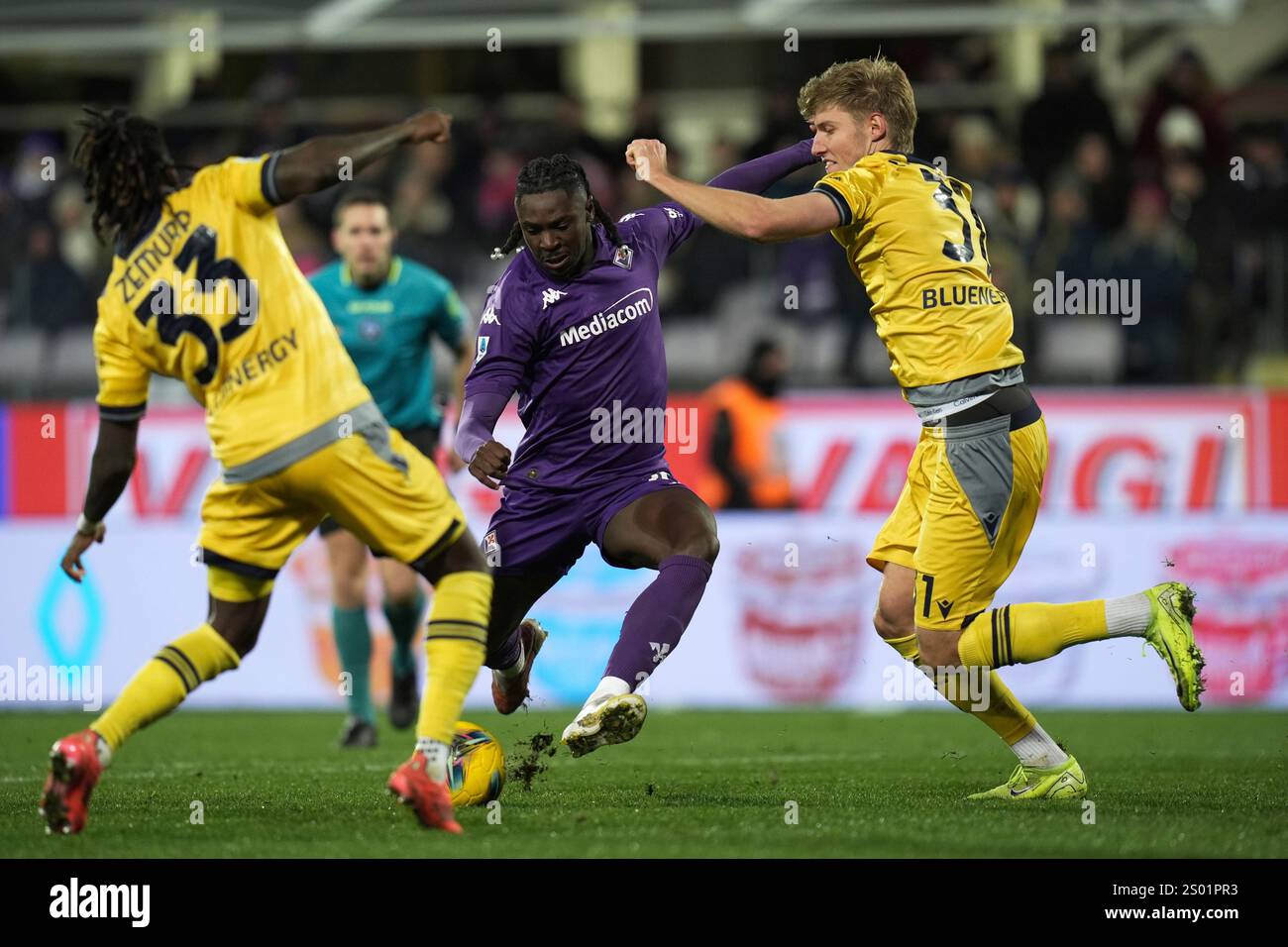 Fiorentina's Moise Kean, centre, fights for the ball with Udinese's ...