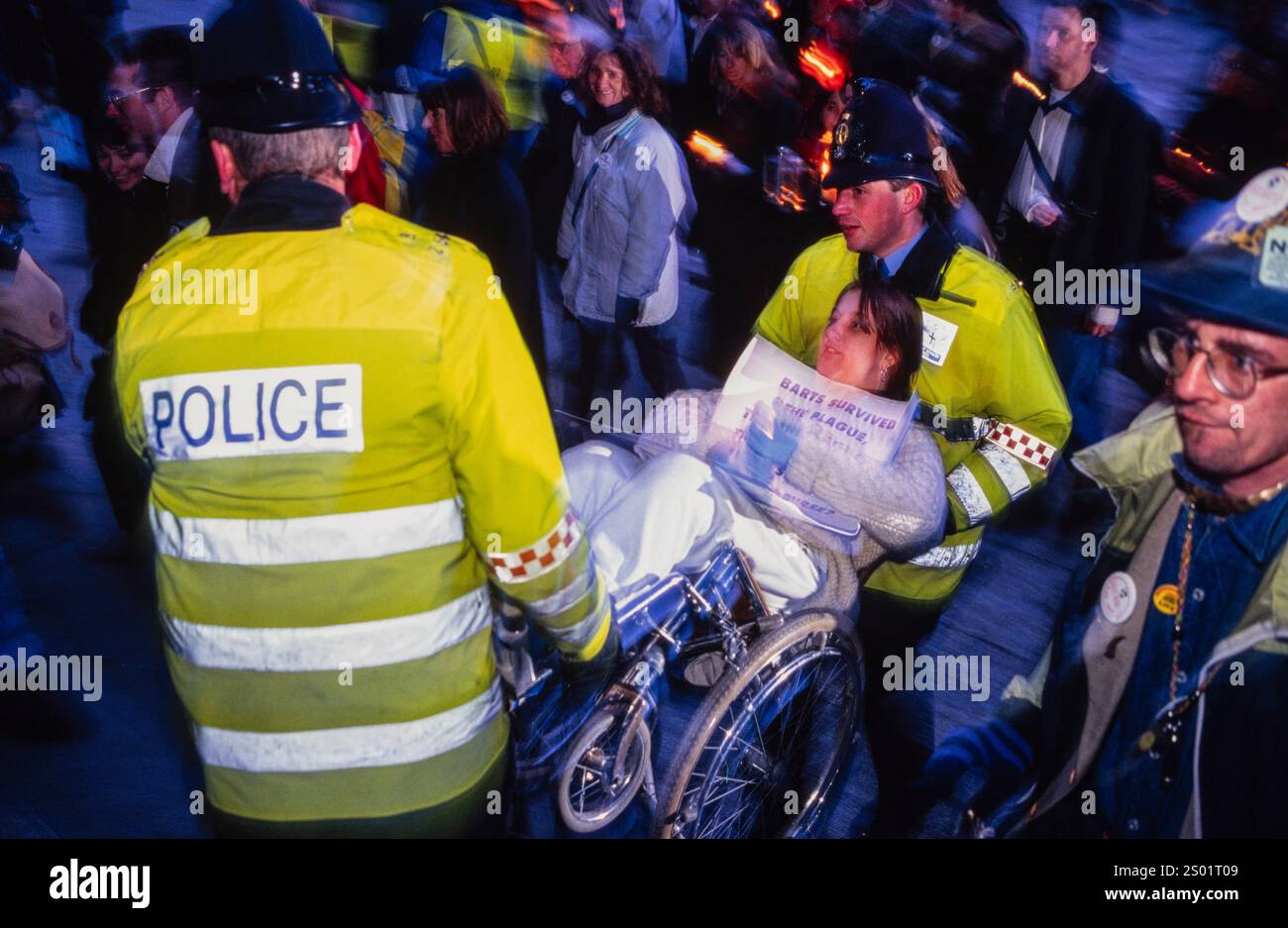 The police helping a protester in a wheelchair up some stairs during a ...