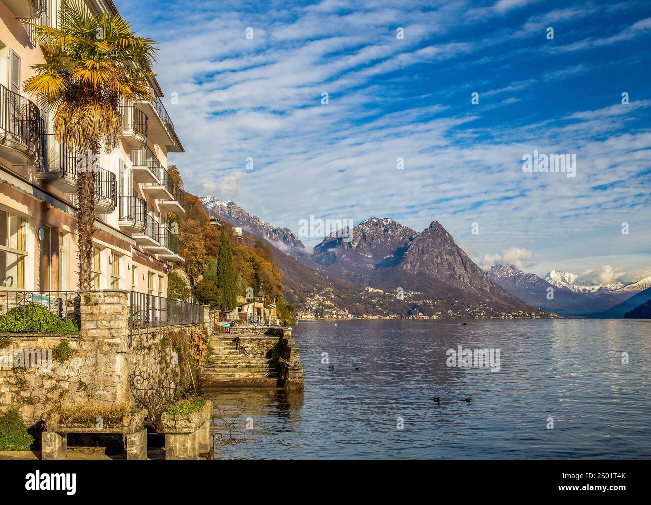 Amazing winter landscape on lake Lugano with snowcapped mountains. Some ...