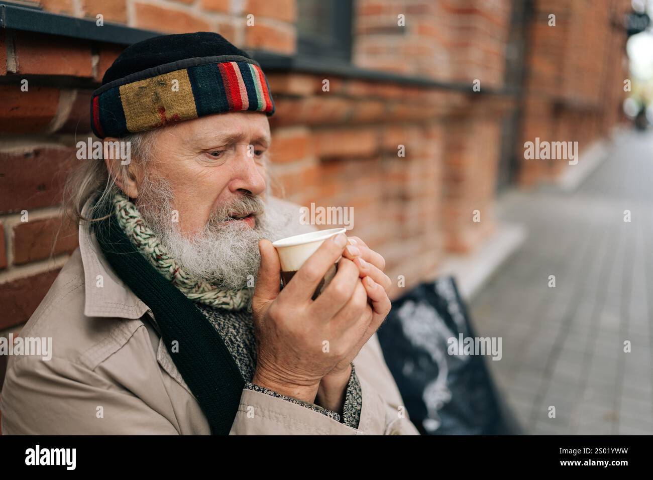 Closeup face of freezing aged homeless man sitting on city street ...