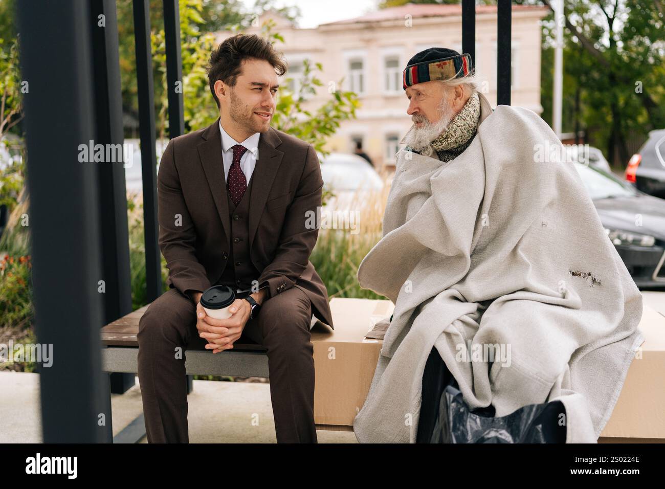 Empathetic businessman in suit listening story of old homeless man ...