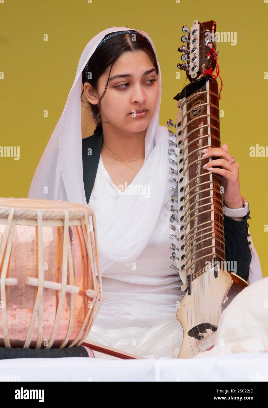 Young female musician performing on the dilruba at the Vaisakhi ...
