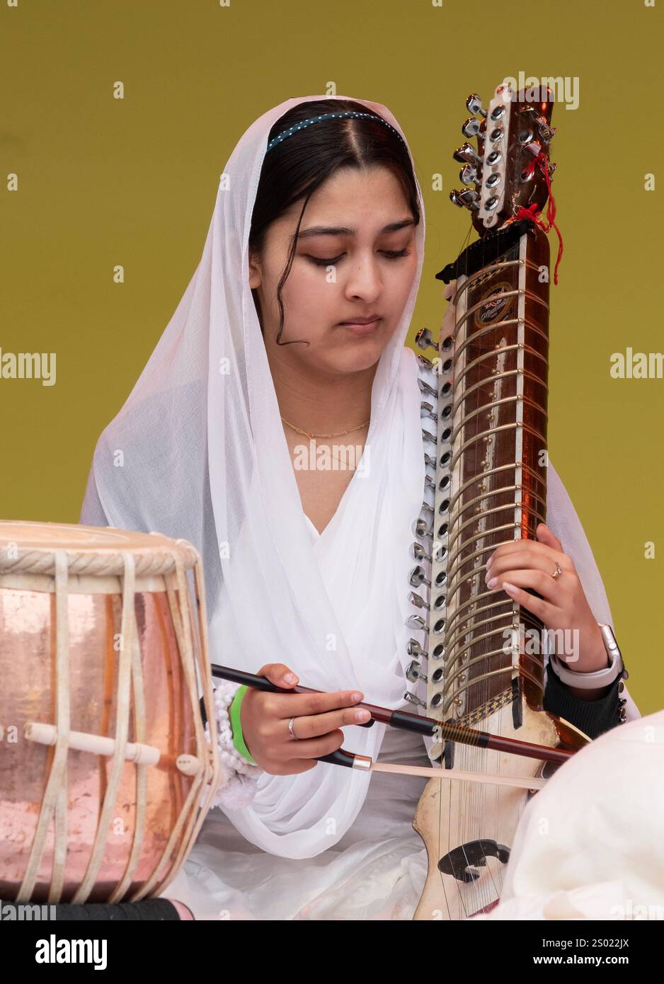 Young female musician performing on the dilruba at the Vaisakhi ...