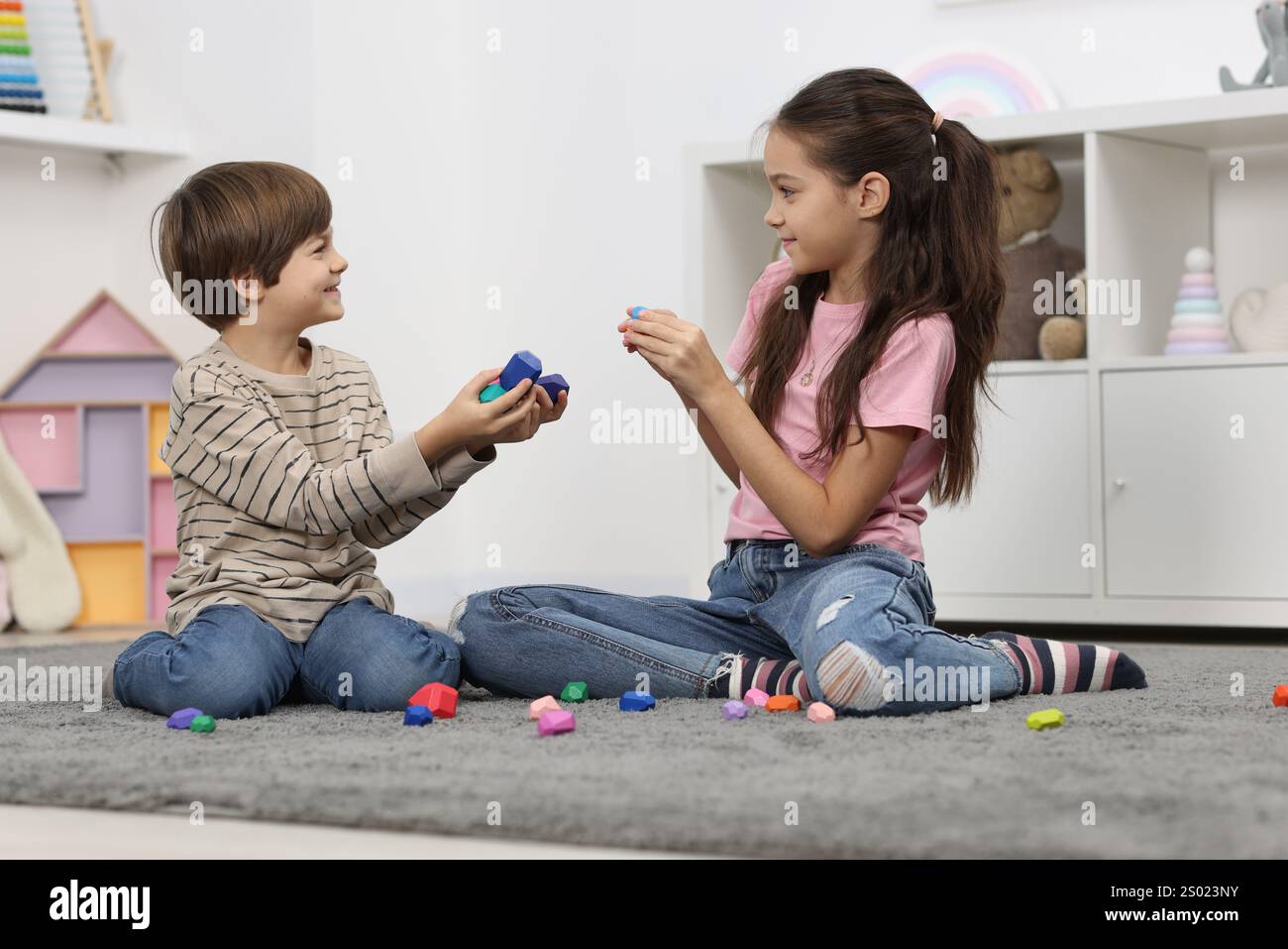 Children playing with balancing stones on floor indoors Stock Photo - Alamy