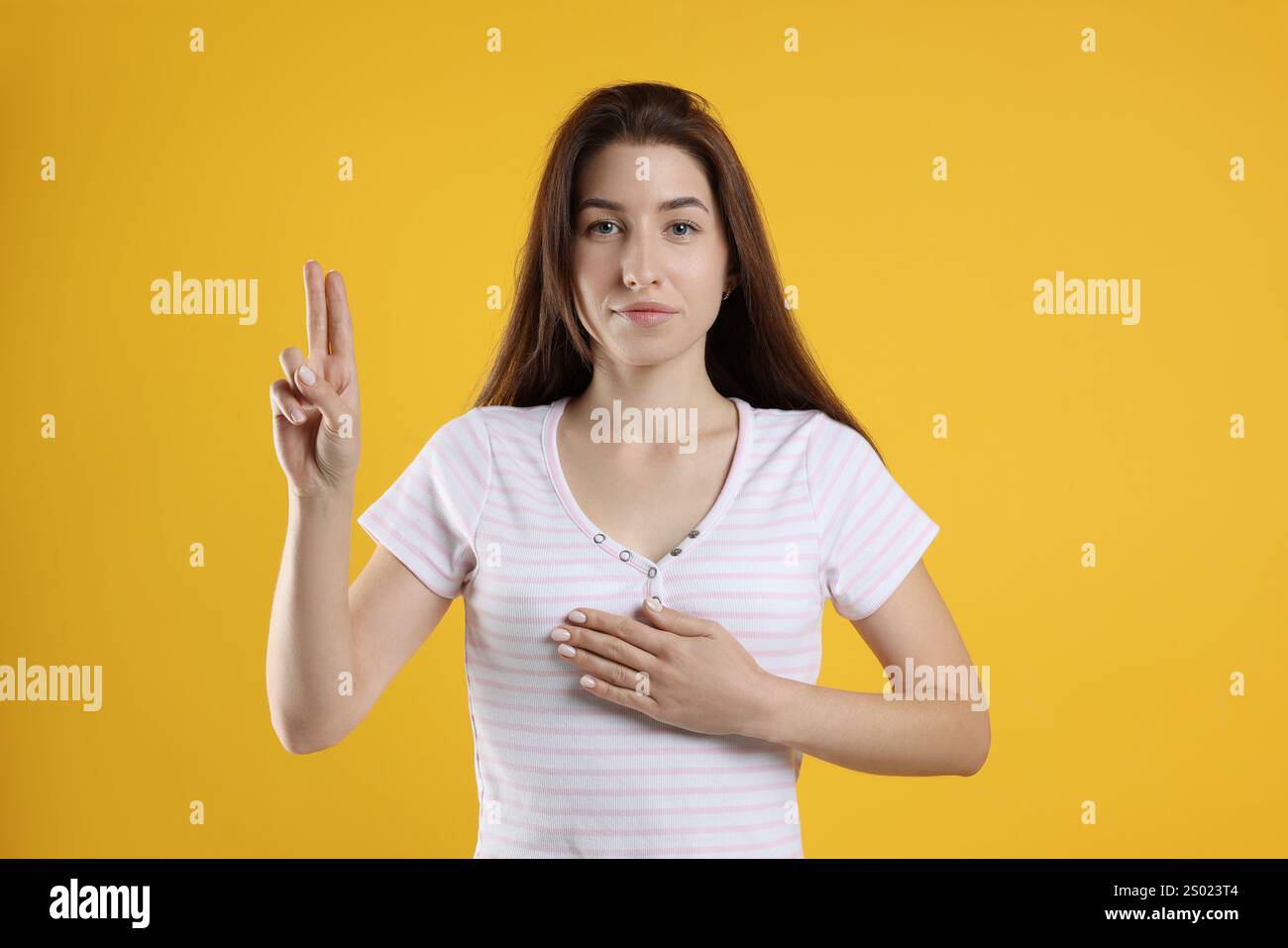 Woman showing oath gesture on orange background. Making promise Stock ...