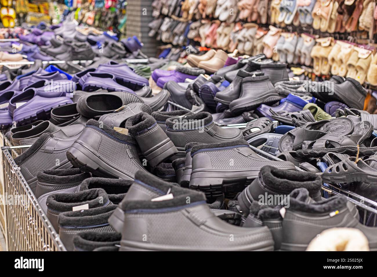 rubber galoshes and crocs in a container in a supermarket Stock Photo ...