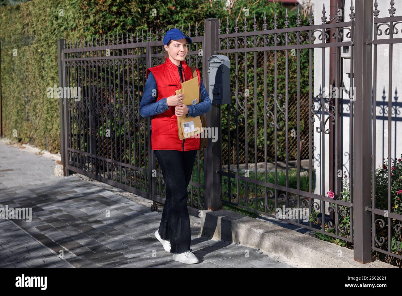 Mailwoman in uniform with envelopes outdoors. Postal service Stock ...
