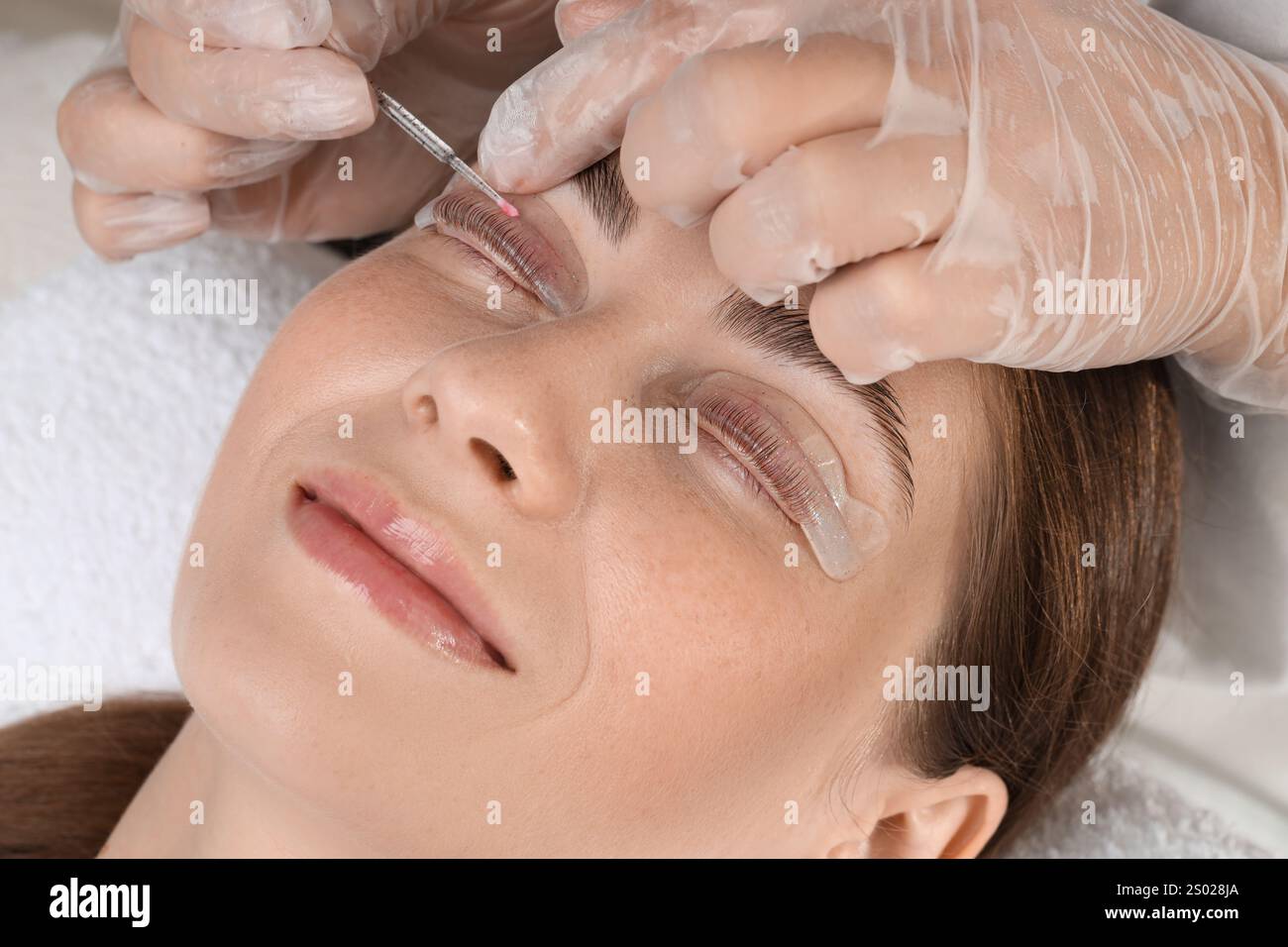 Eyelash lamination procedure. Esthetician sticking woman's lashes to ...