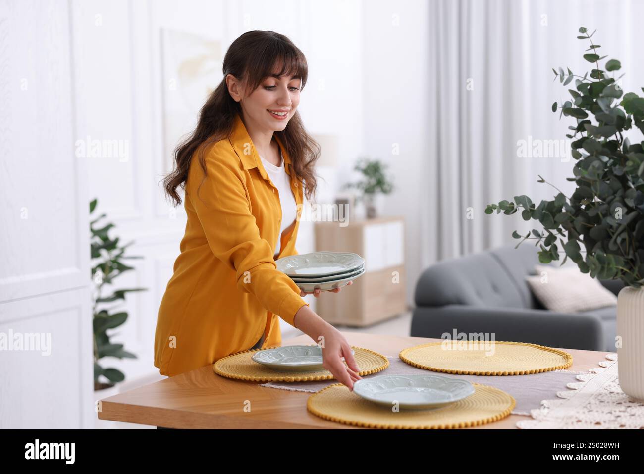 Woman setting table for dinner at home Stock Photo - Alamy