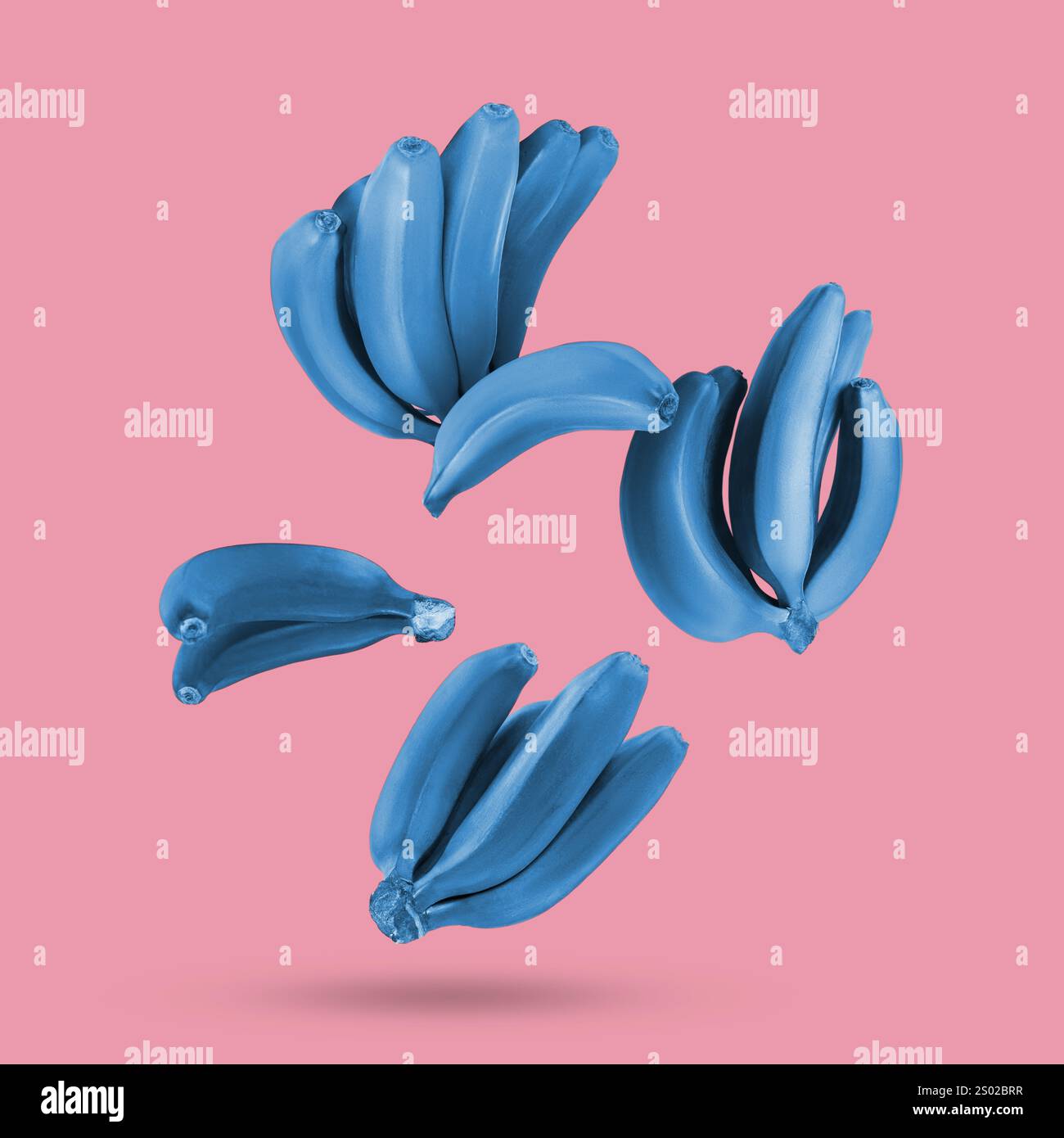 Light blue bananas in air on pink background Stock Photo - Alamy