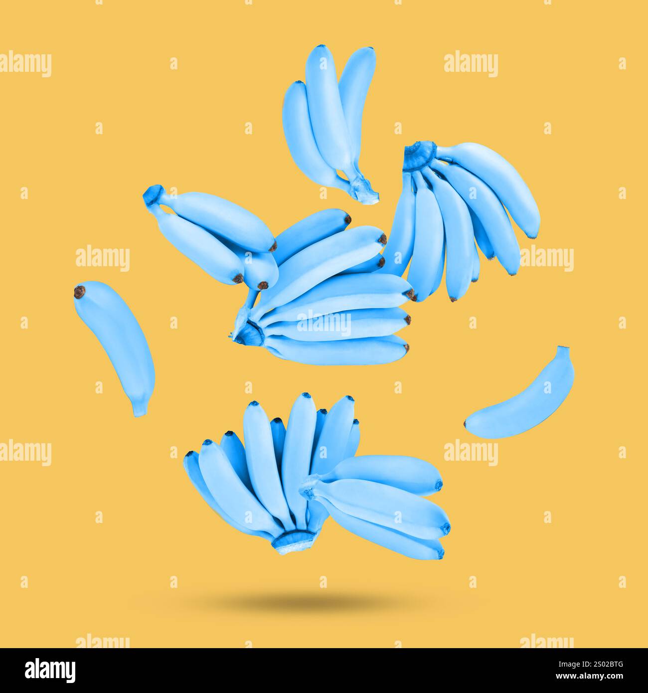 Light blue bananas in air on pale orange background Stock Photo - Alamy