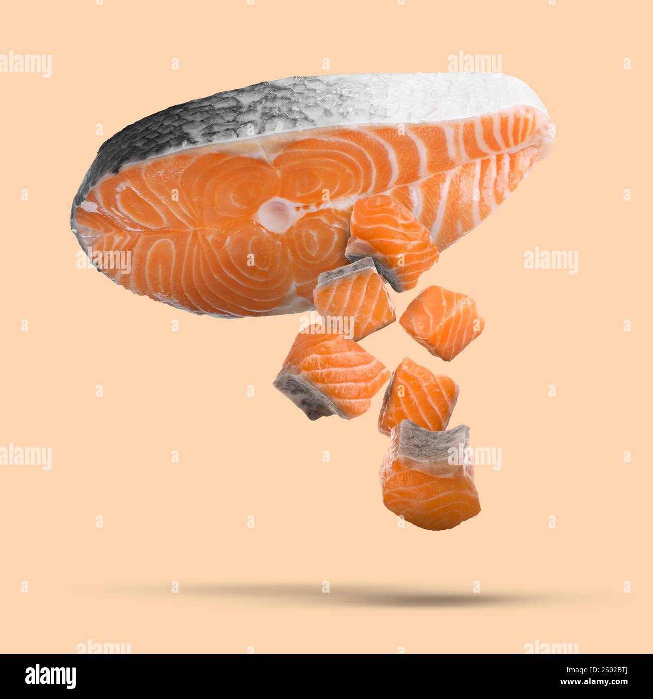 Red fish steak and pieces falling on beige background Stock Photo - Alamy
