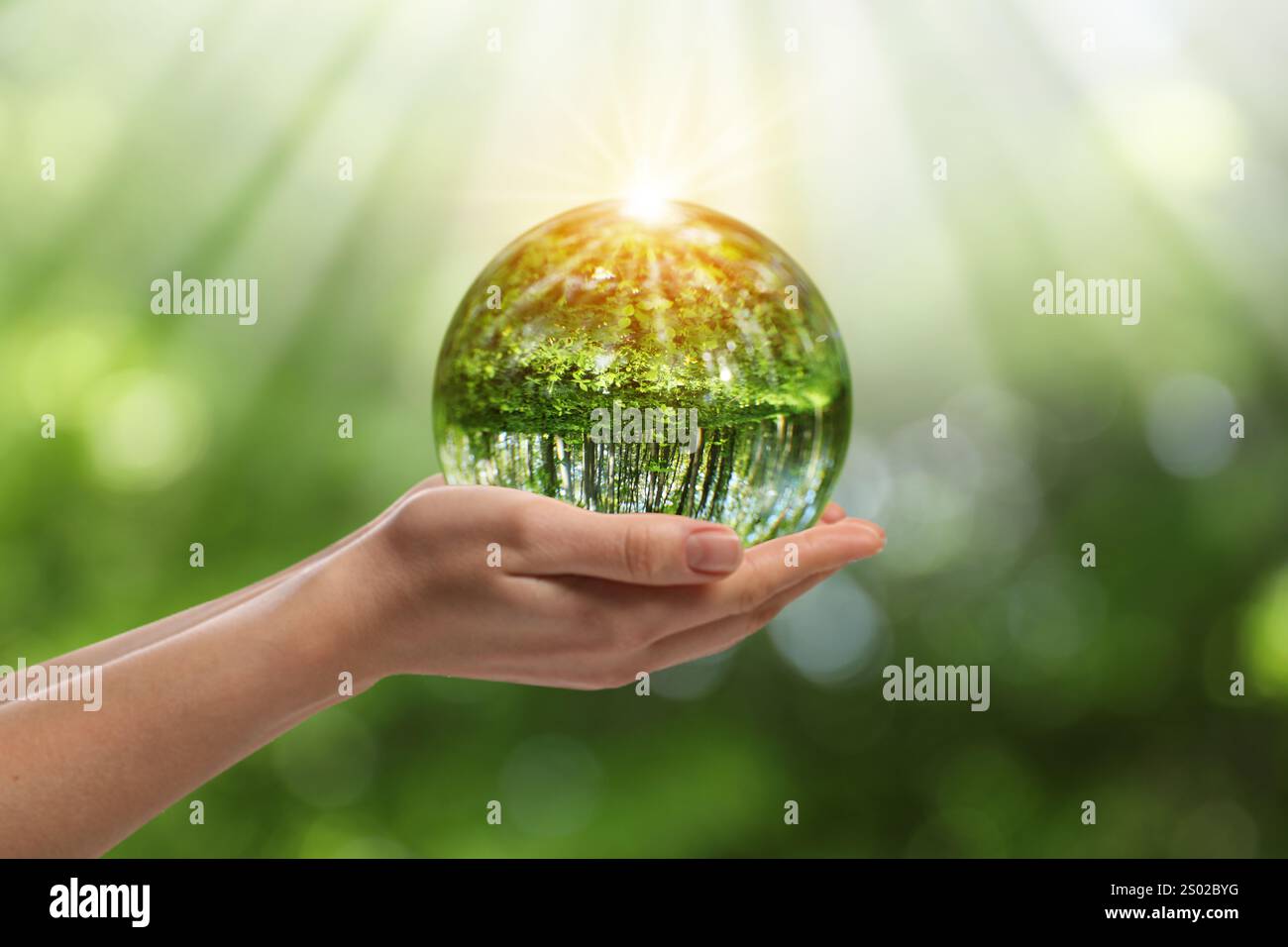 Save Earth. Woman holding ball lens with overturned reflection of green ...