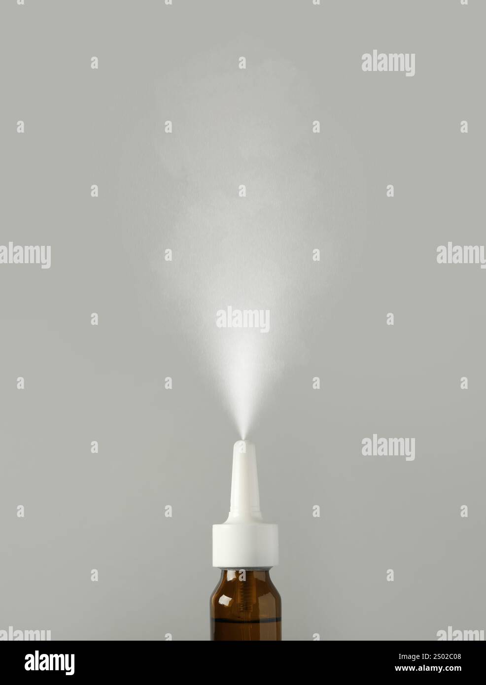 Nasal spray with sprinkled medication over nozzle on grey background ...