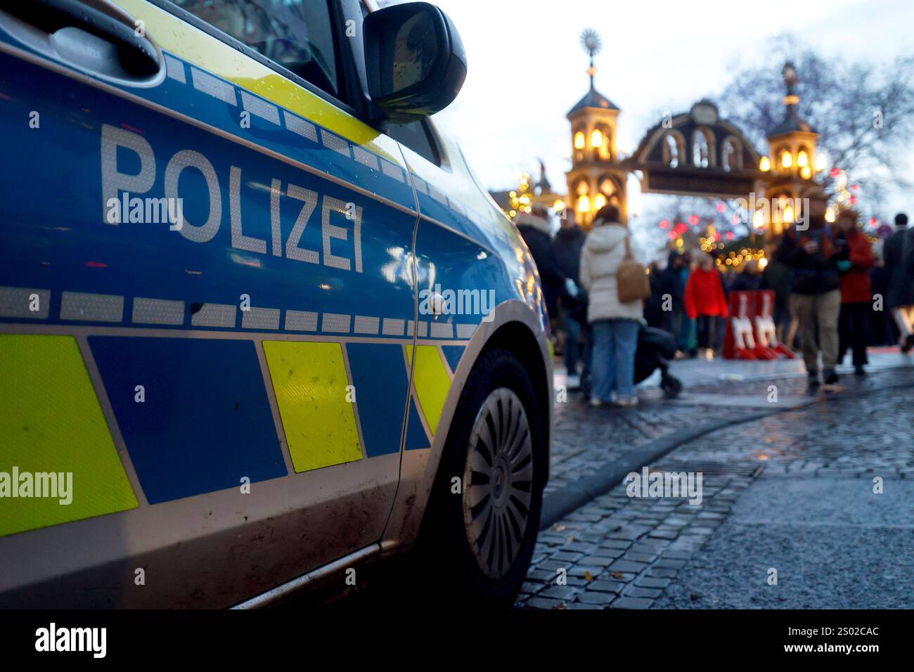 Ein Polizeiauto steht neben den Absperrungen gegen Anschläge mit ...