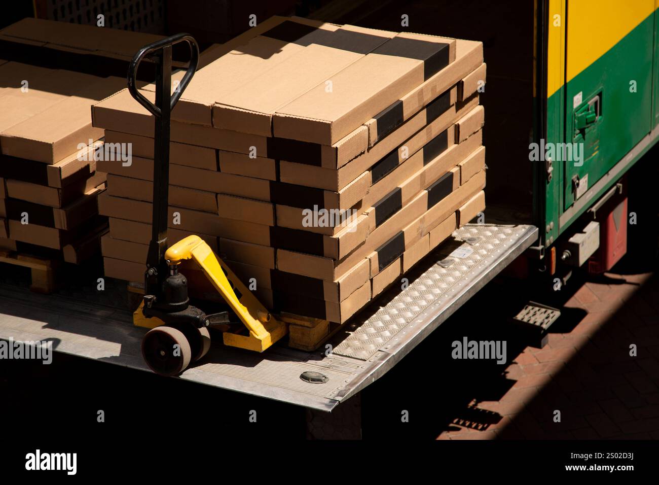 A stack of cardboard boxes on a pallet is being loaded or unloaded from ...