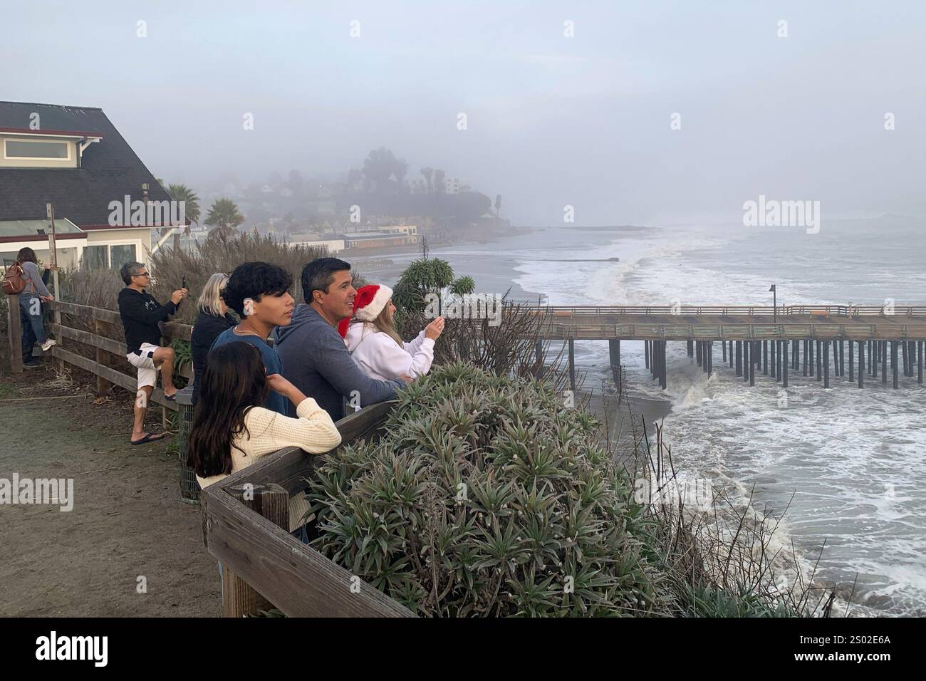 Spectators watch high surf roll in near the Capitola Wharf, Monday, Dec ...