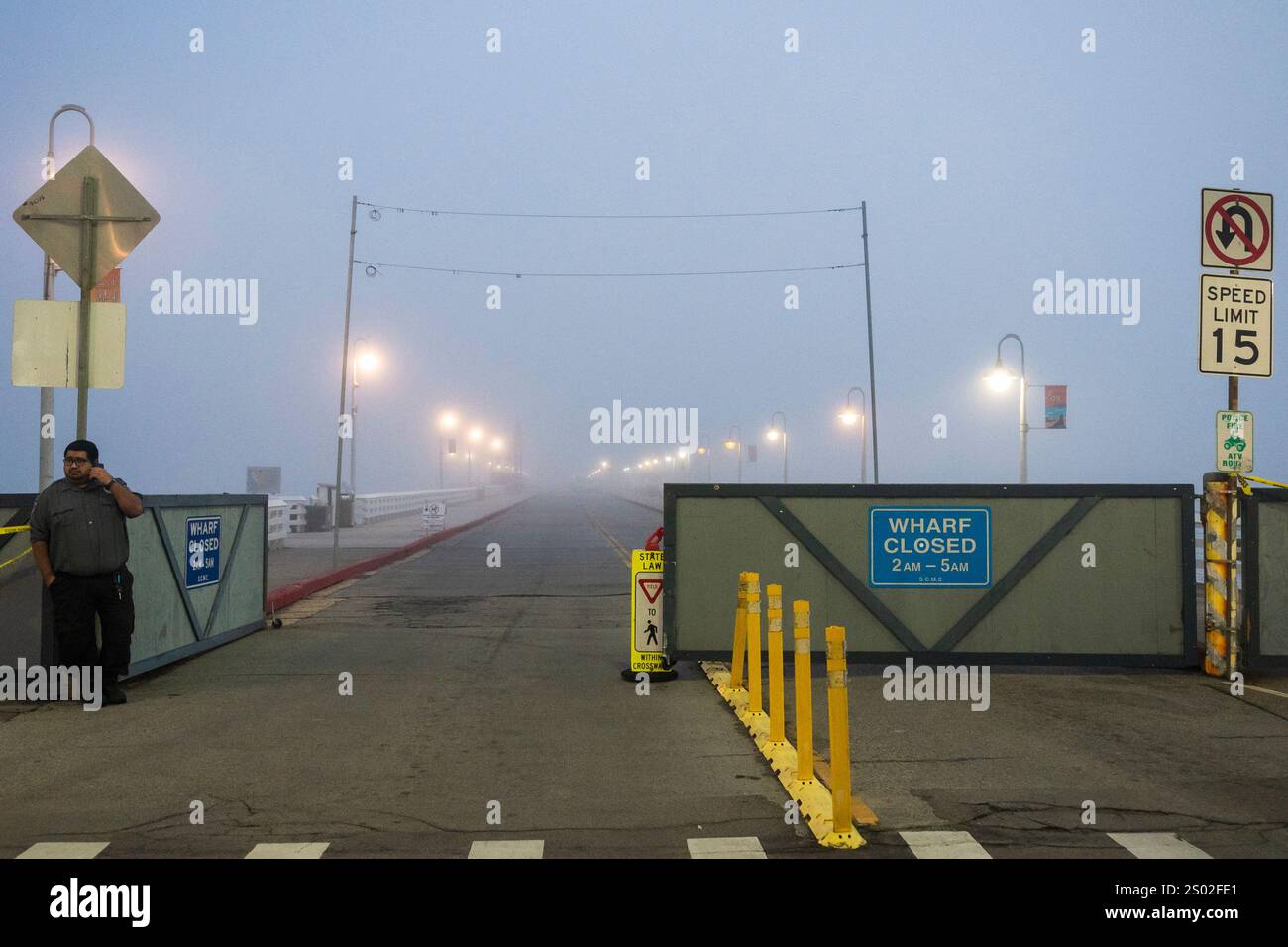 A security guard watches the entrance to the closed Santa Cruz Wharf in ...