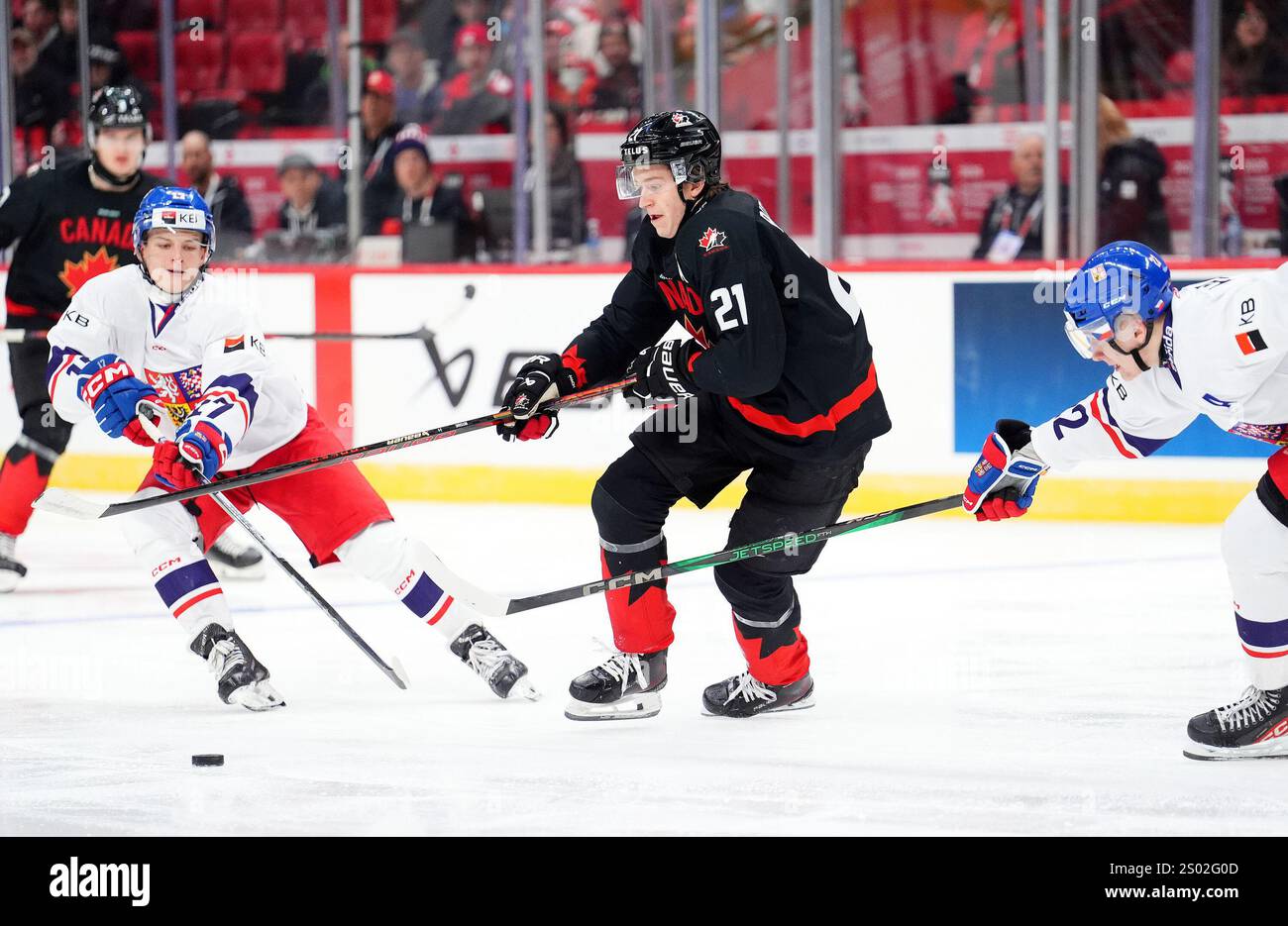 Canada's Calum Ritchie (21) moves the puck between Czechia's Petr ...
