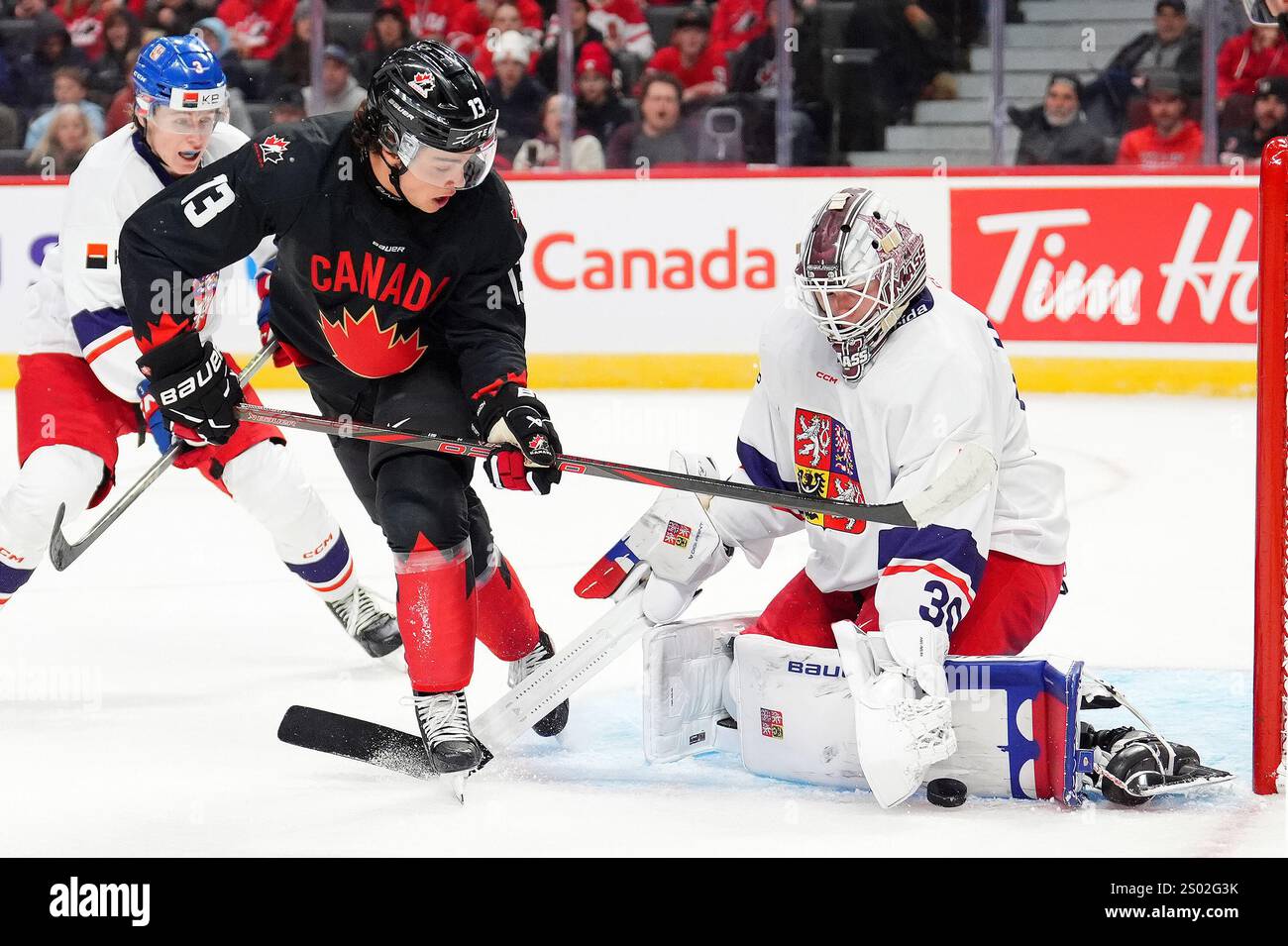 Canada's Luca Pinelli (13) tries to get the puck past Czechia's Michael ...