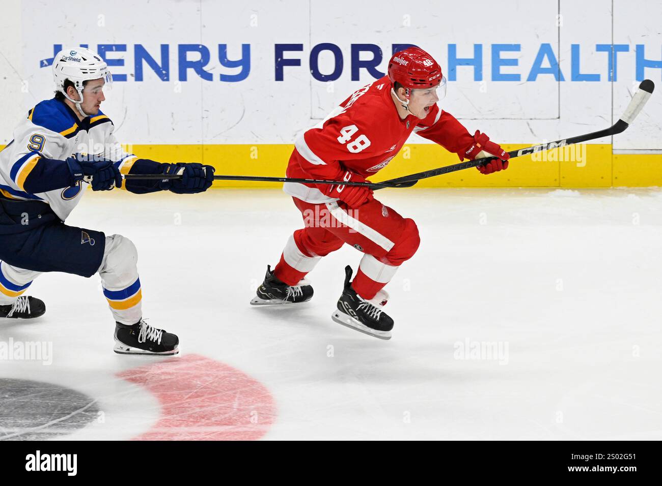 Detroit Red Wings right wing Jonatan Berggren, right, is hooked from ...