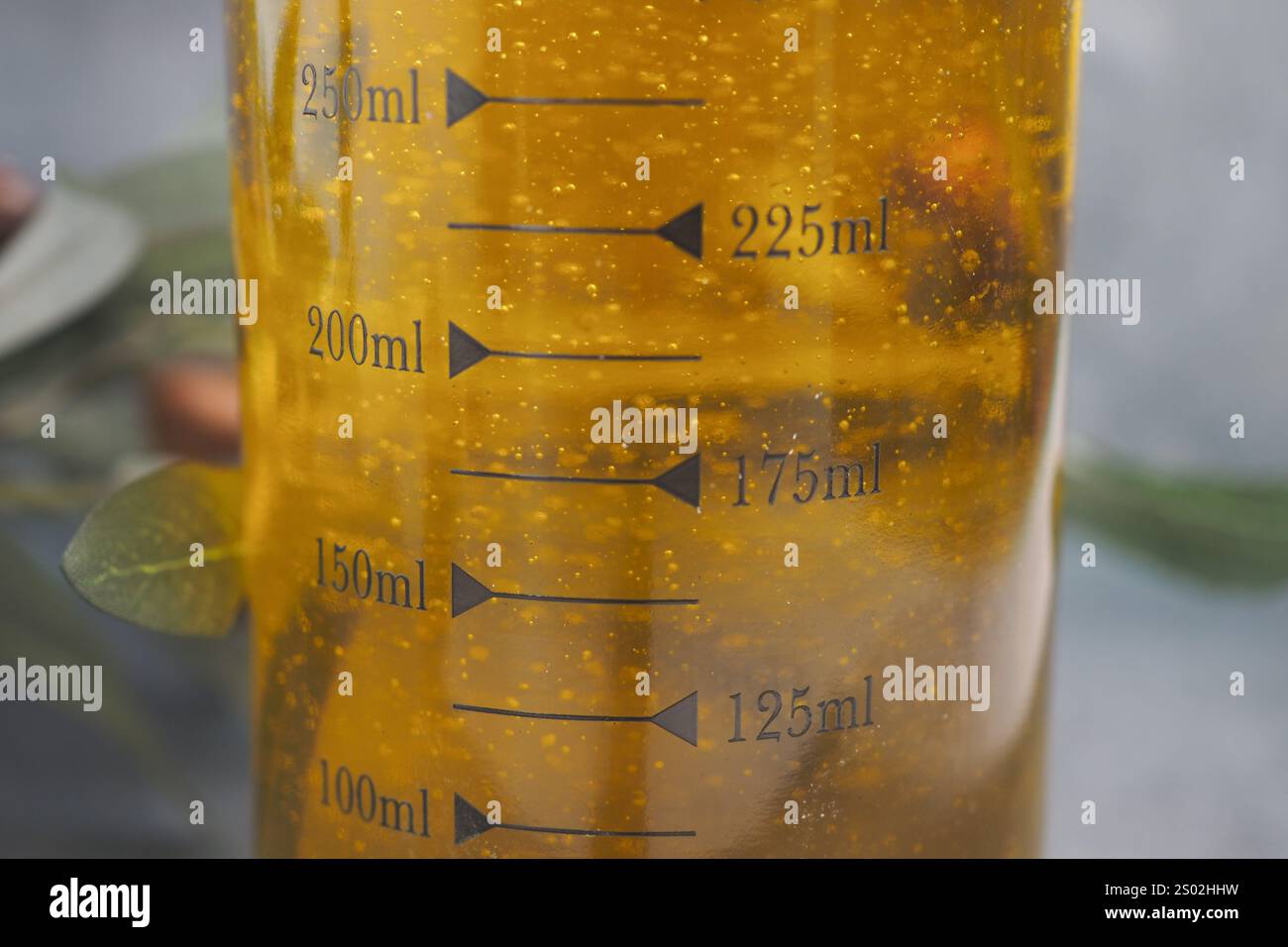 Carefully measuring oil using a transparent glass jug along with a ...