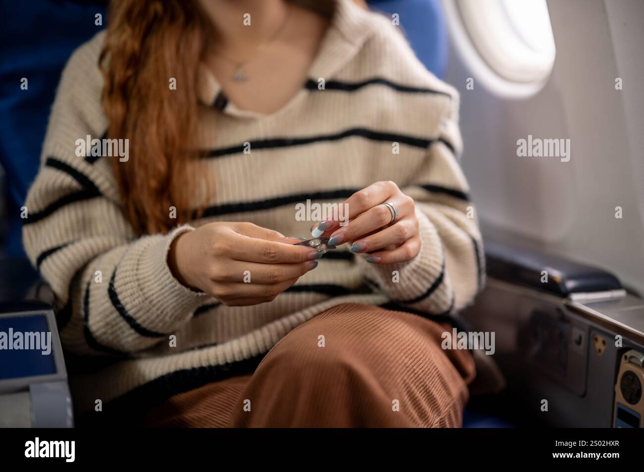 A close-up of a woman taking an airsick pill at her seat before the ...