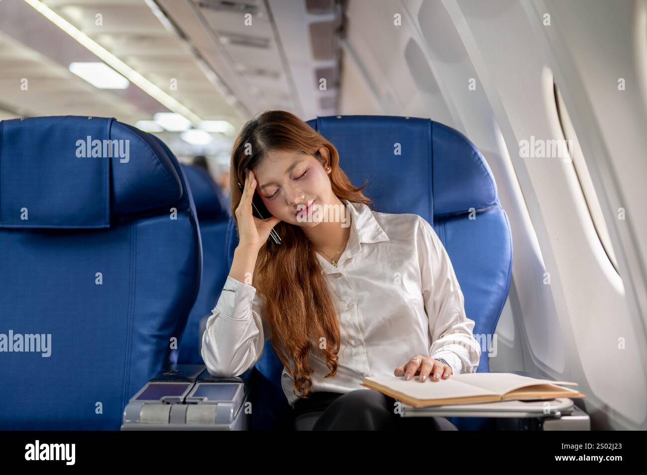 A tired Asian businesswoman feels dizzy from reading during the long ...