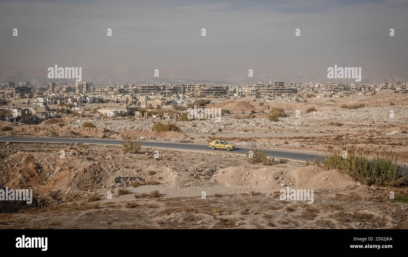 Hama, Syria. 12th Dec, 2024. A taxi drives past Jobar on the outskirts ...