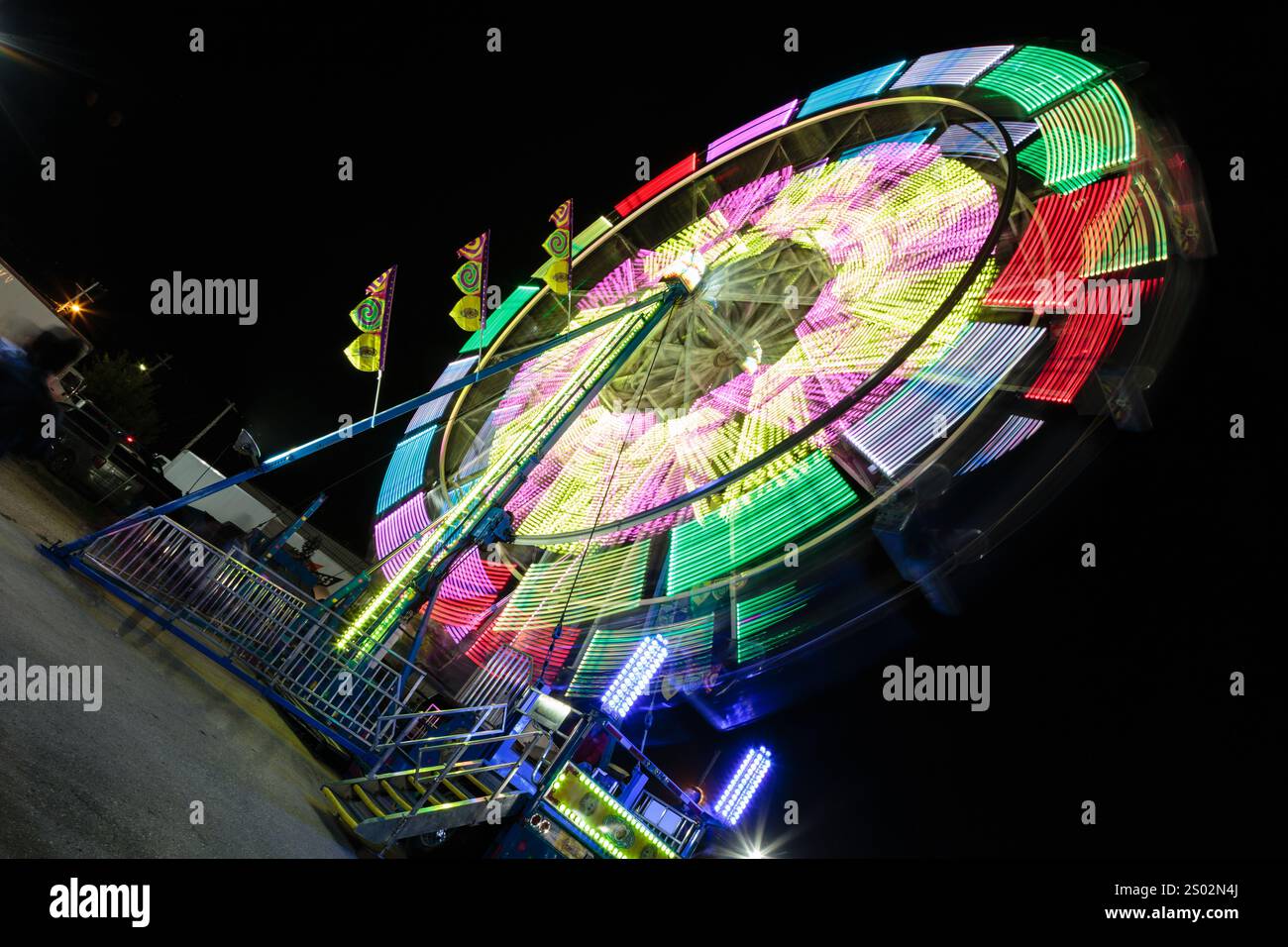 A colorful merry go round with lights on it. The lights are bright and ...