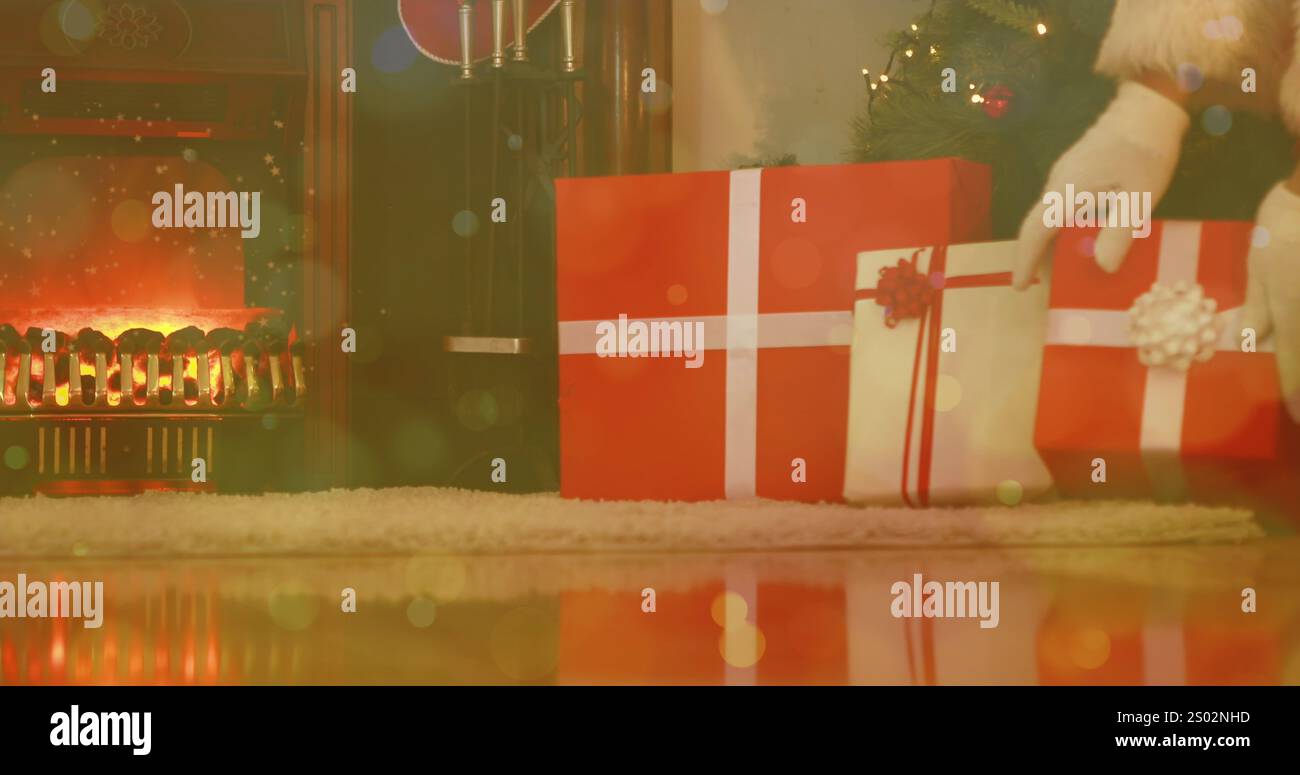 Image of white light spots over santa leaving christmas gifts under ...