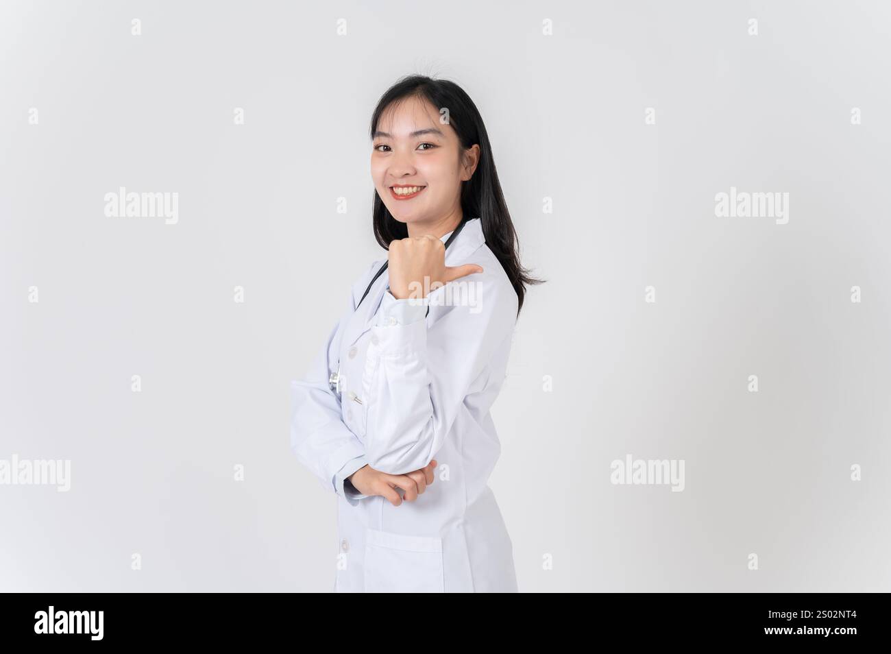 A beautiful, smiling Asian female doctor in a white gown uniform ...