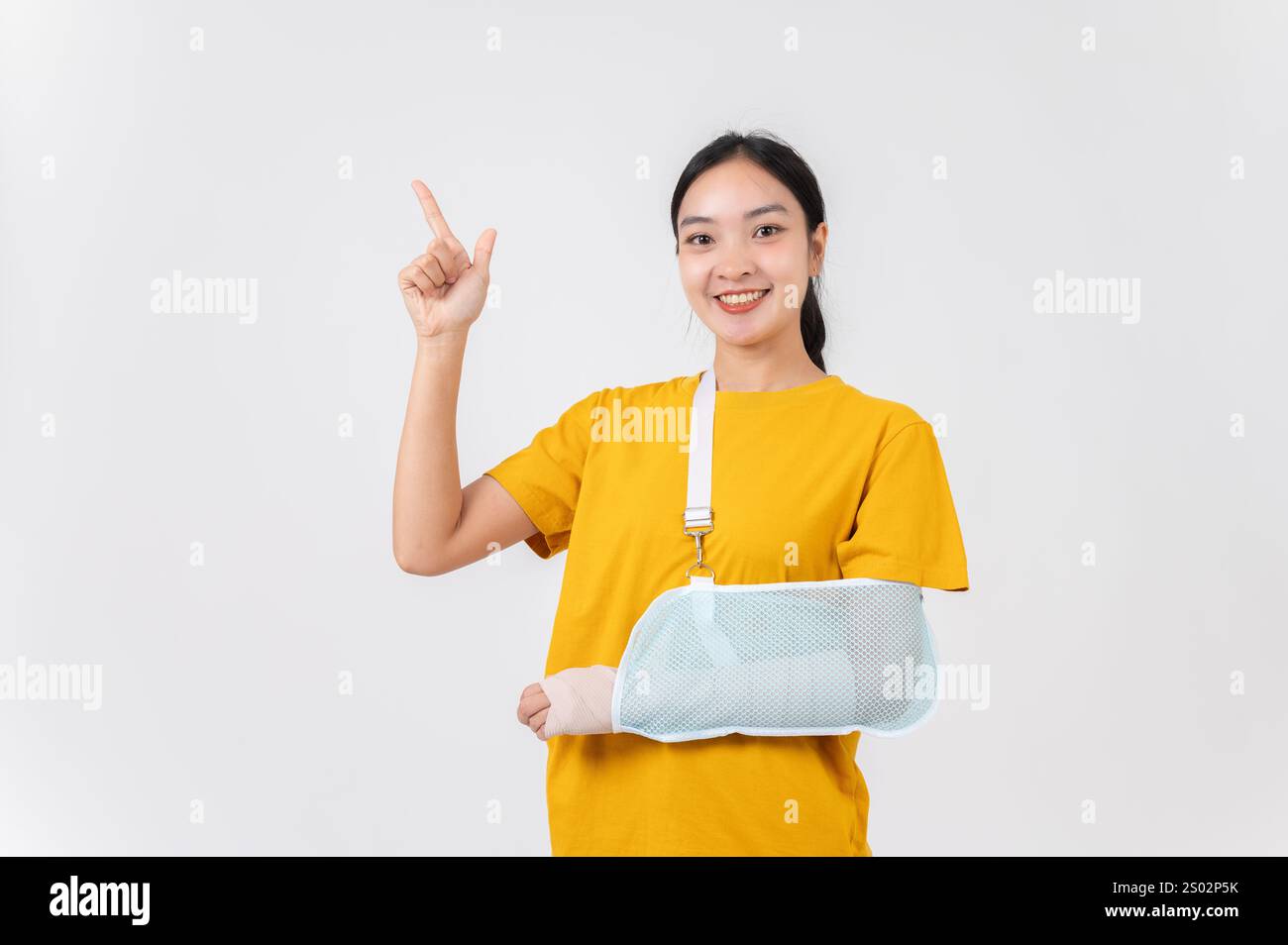 A smiling Asian woman with her broken arm, wrapped in a plaster bandage ...