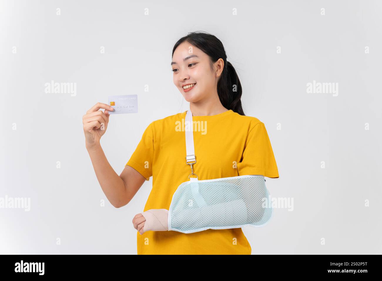 A smiling, carefree Asian woman with her broken arm, wrapped in a ...