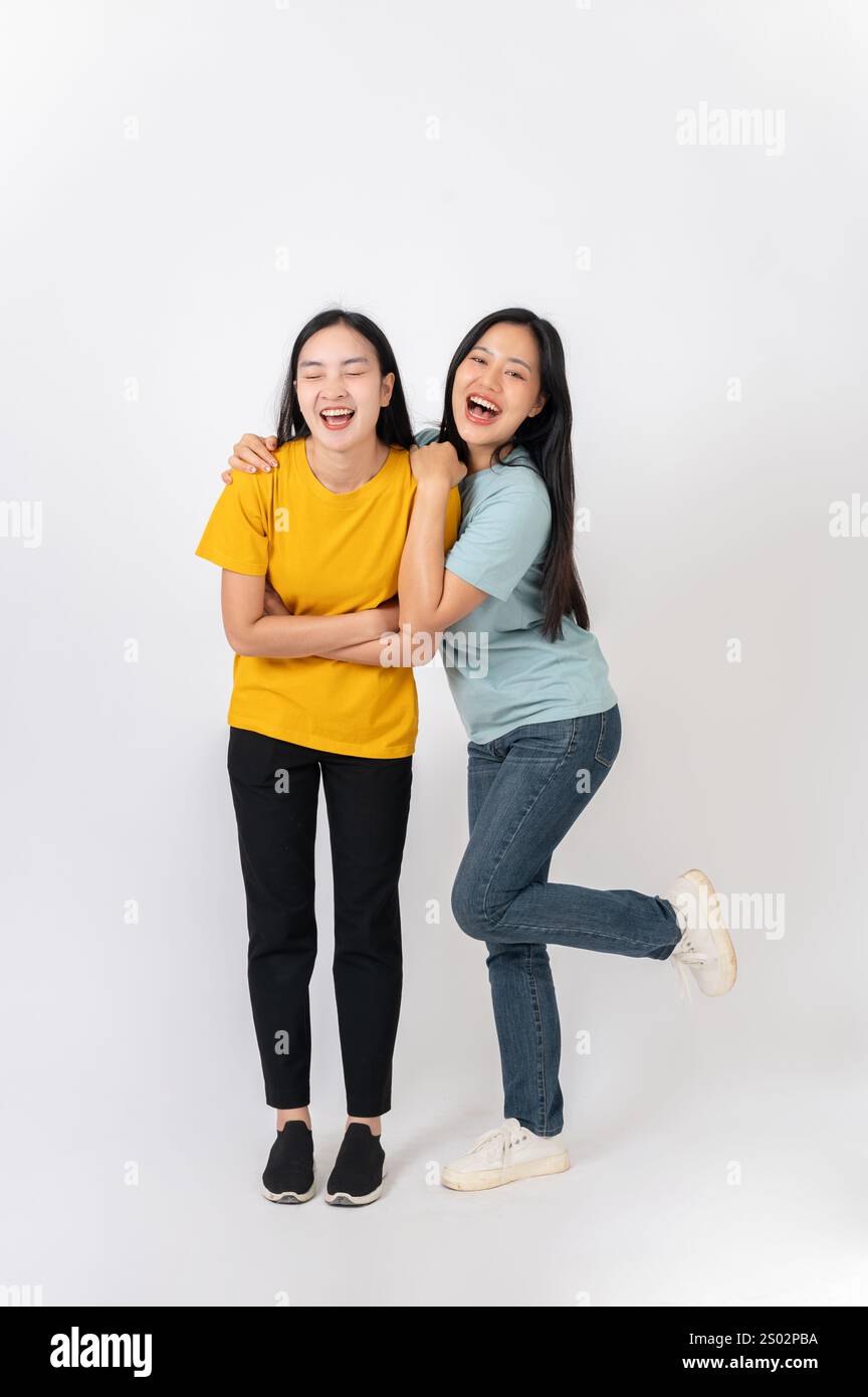 A full-body image of two lovely, cheerful Asian female best friends in ...