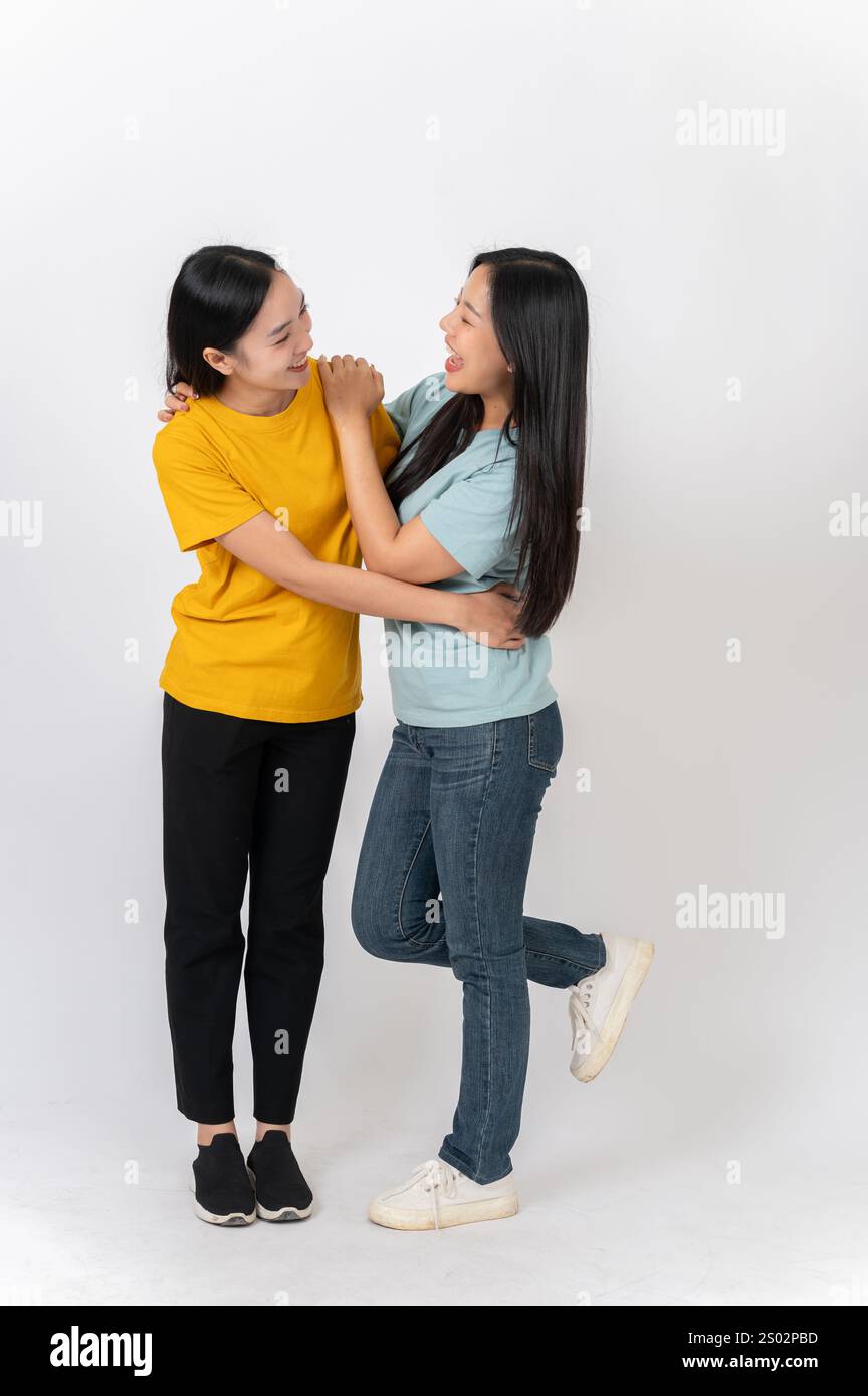 A full-body image of two lovely, cheerful Asian female best friends in ...