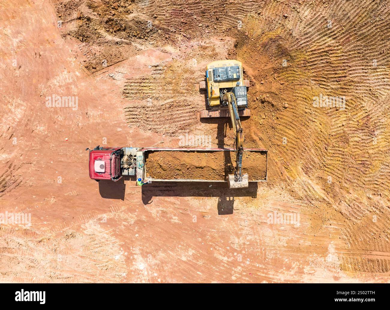 Excavator on earthmoving with grab crane unloads sand from freight car ...