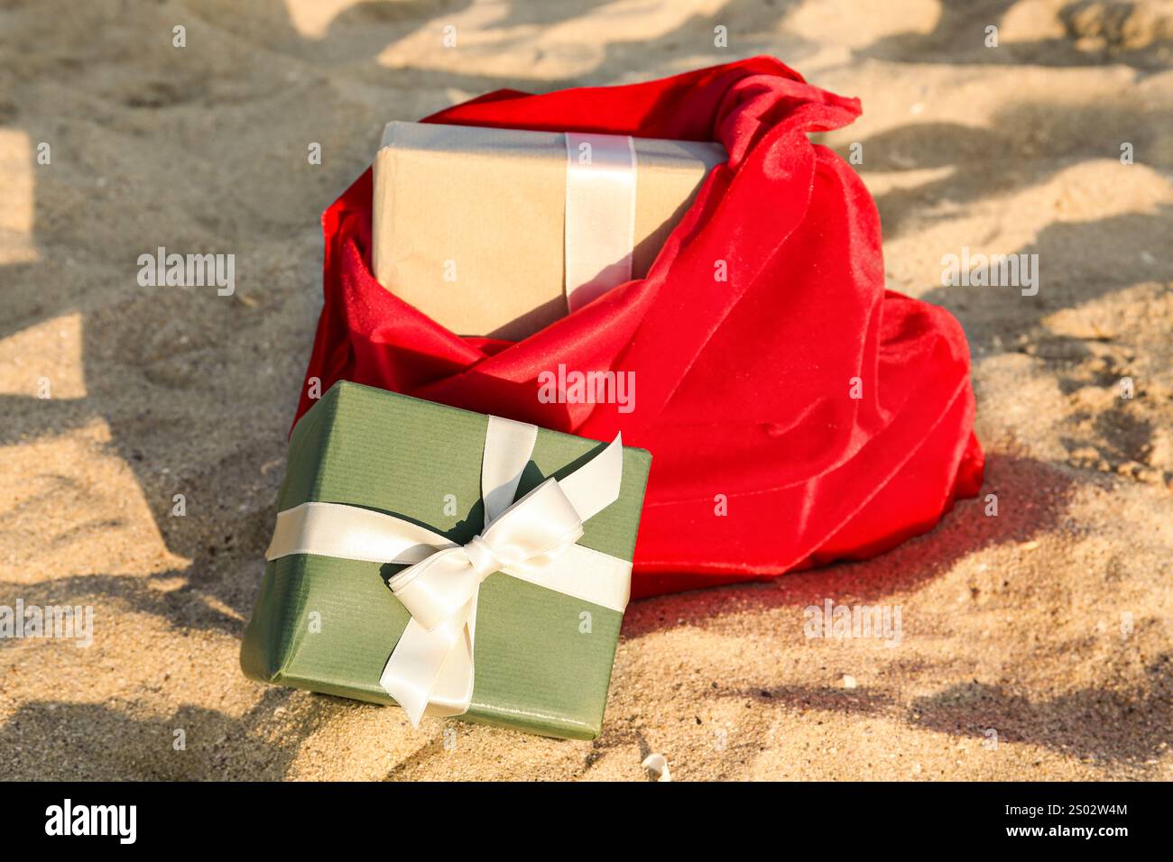 Red Santa bag with gift boxes on beach. Christmas vacation concept ...
