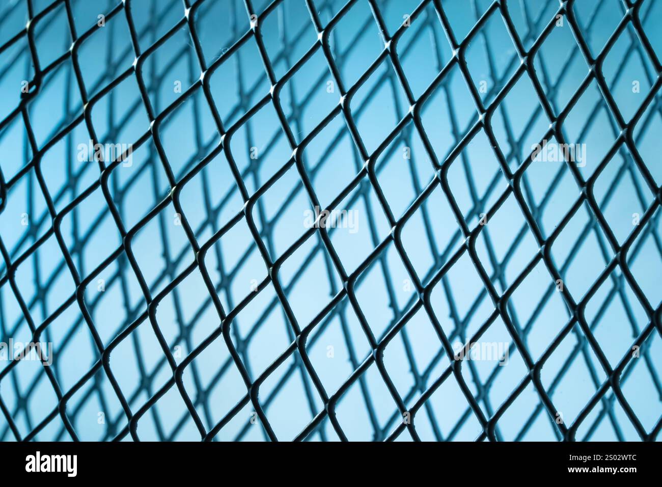 Steel mesh netting with blue background Stock Photo - Alamy