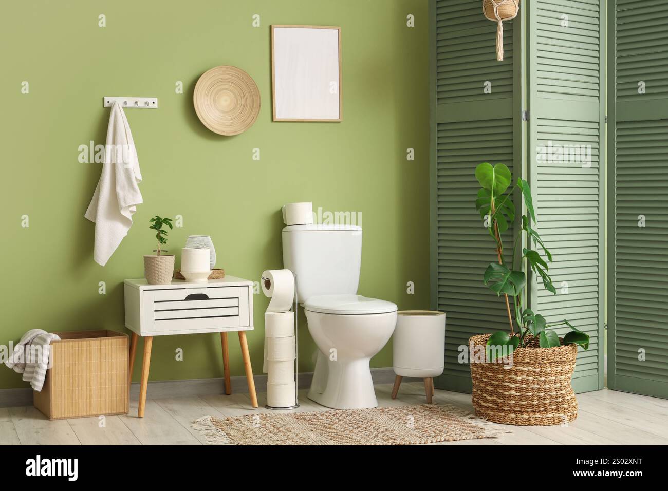 Toilet bowl, bedside table and houseplant in restroom Stock Photo - Alamy
