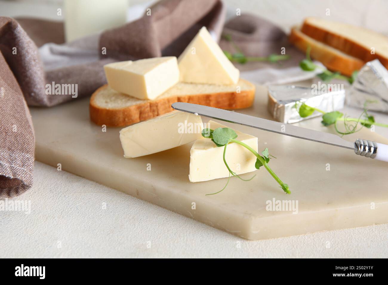 Board with triangles of tasty processed cheese and micro green on white ...