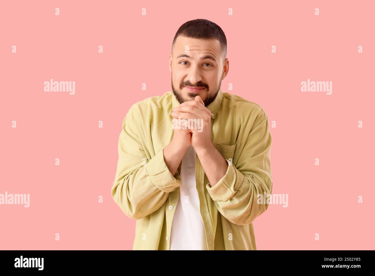 Apologetic young man on pink background Stock Photo - Alamy
