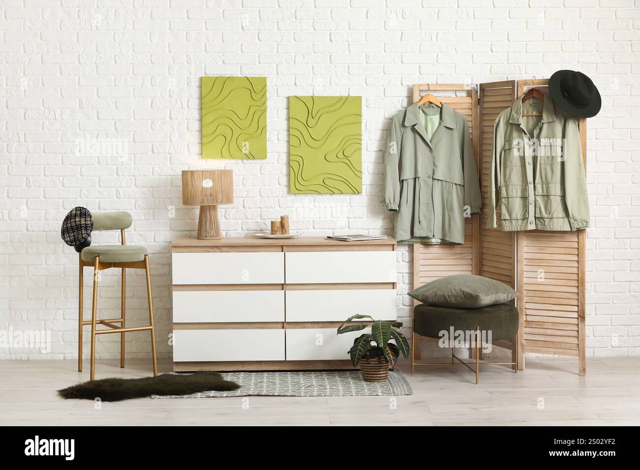 Chest of drawers, paintings, folding screen and hangers with clothes ...