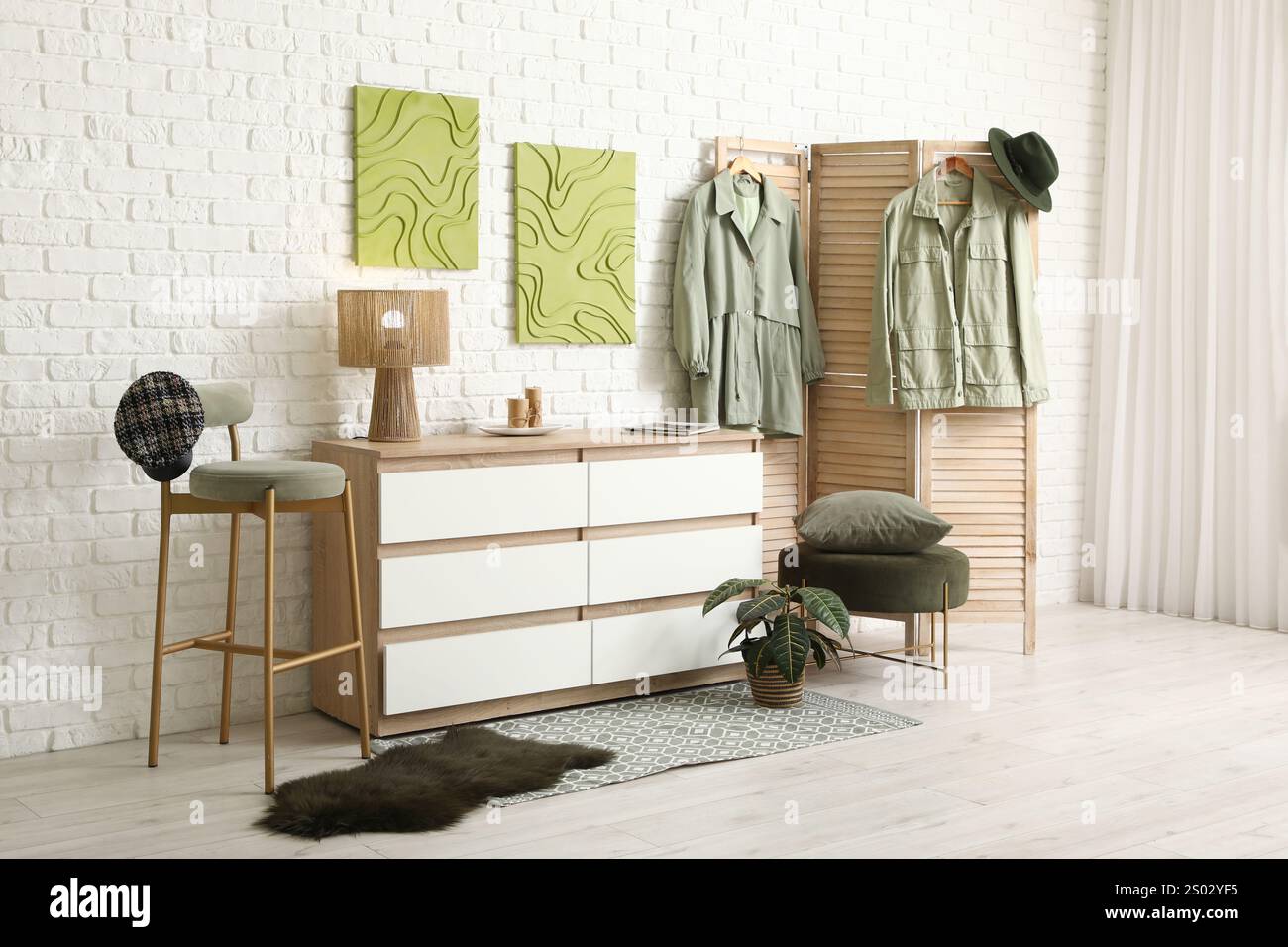 Chest of drawers, paintings, folding screen and hangers with clothes ...