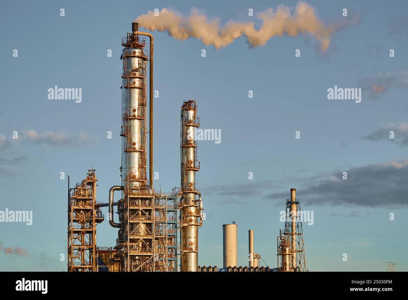 Chemical plant with distillation column releasing steam under a clear ...