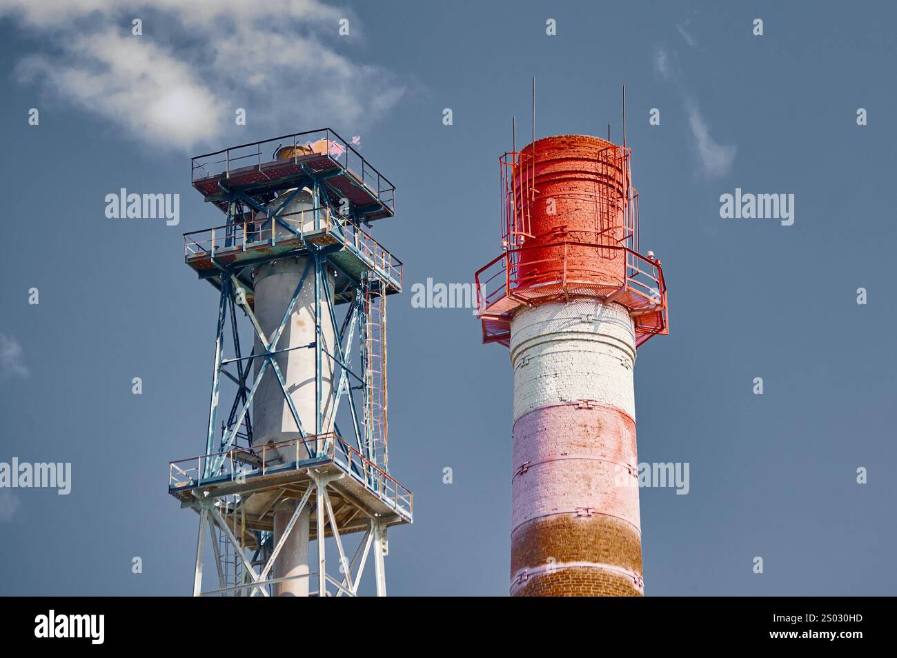 Chemical plant distillation column towers under blue sky with scattered ...