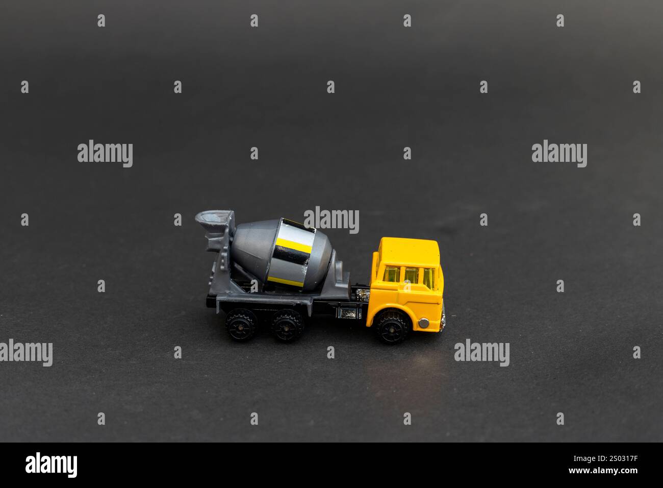 Toy cement mixer truck on black background Stock Photo - Alamy